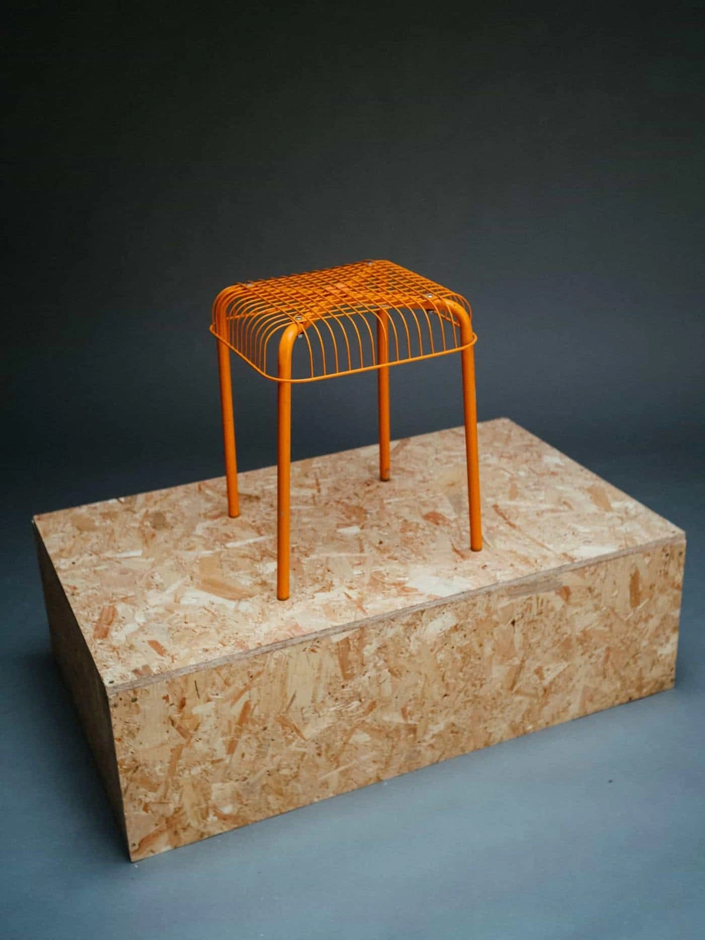 Emilio De Jonghe - Restored orange stool displayed on a podium. – Savee